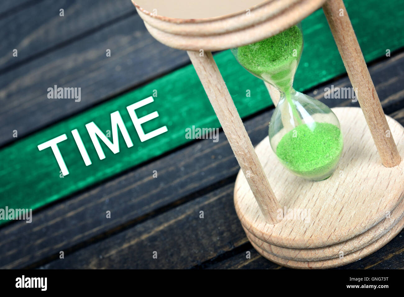 Time text and hourglass on wooden table Stock Photo - Alamy