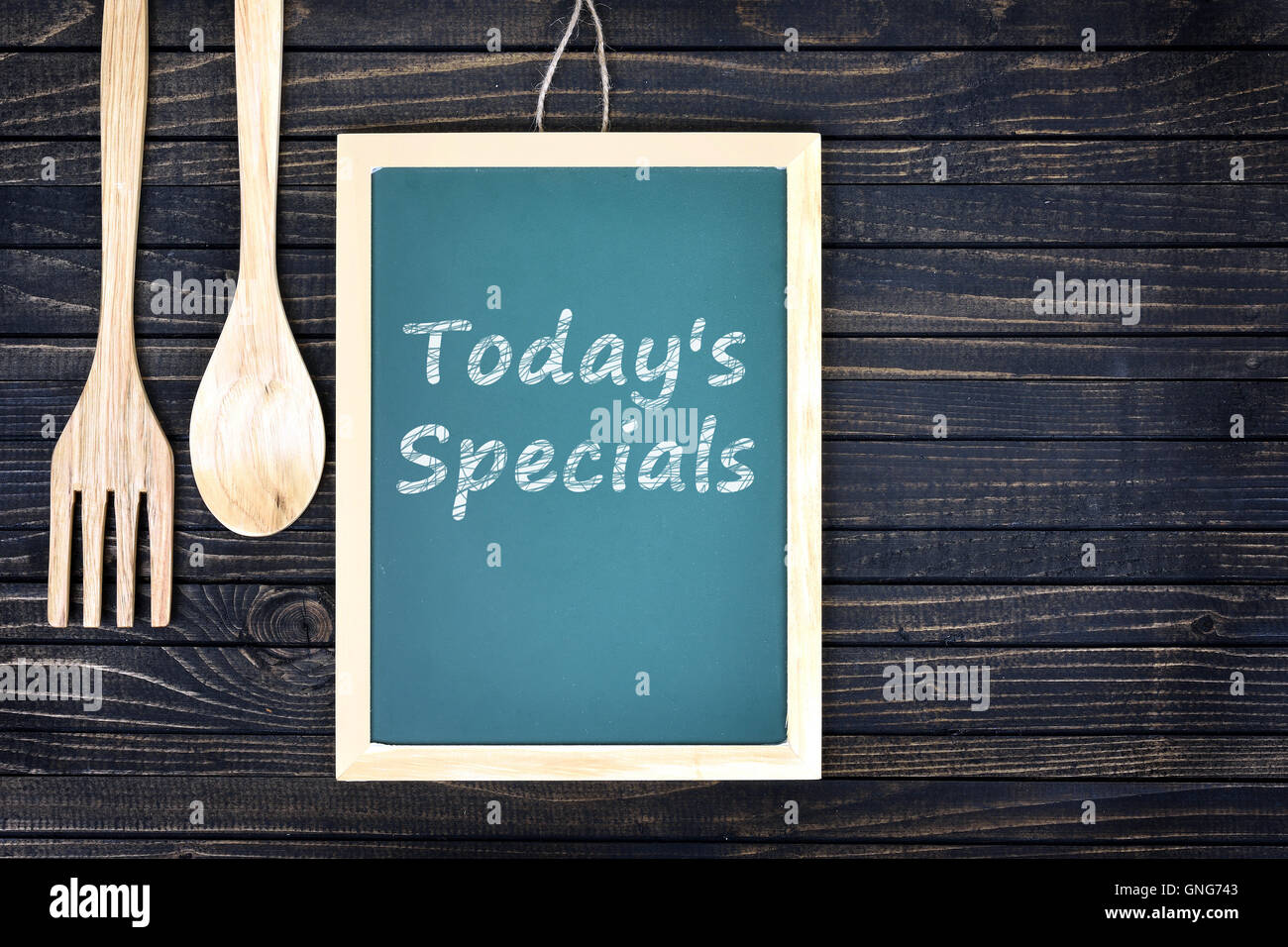 Today's Specials text on green board with fork and spoon on wooden ...