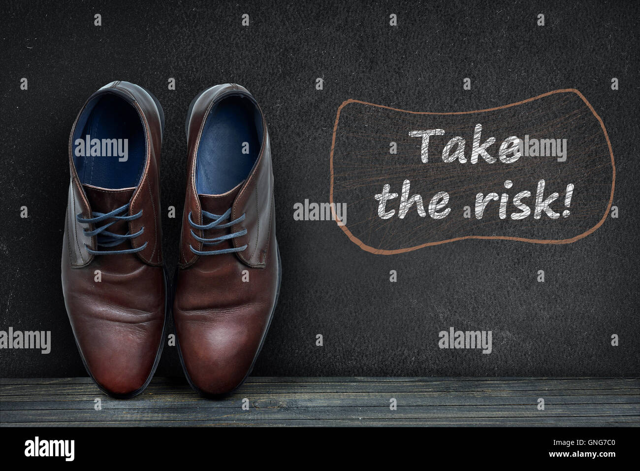 Take the risk text on black board and business shoes on wooden floor ...