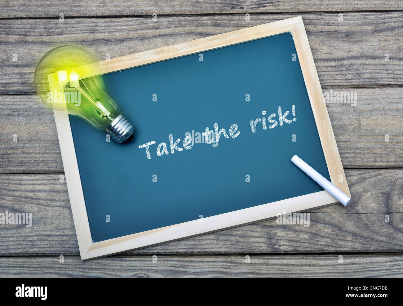 Take the risk text on school board and glowing light bulb Stock Photo ...