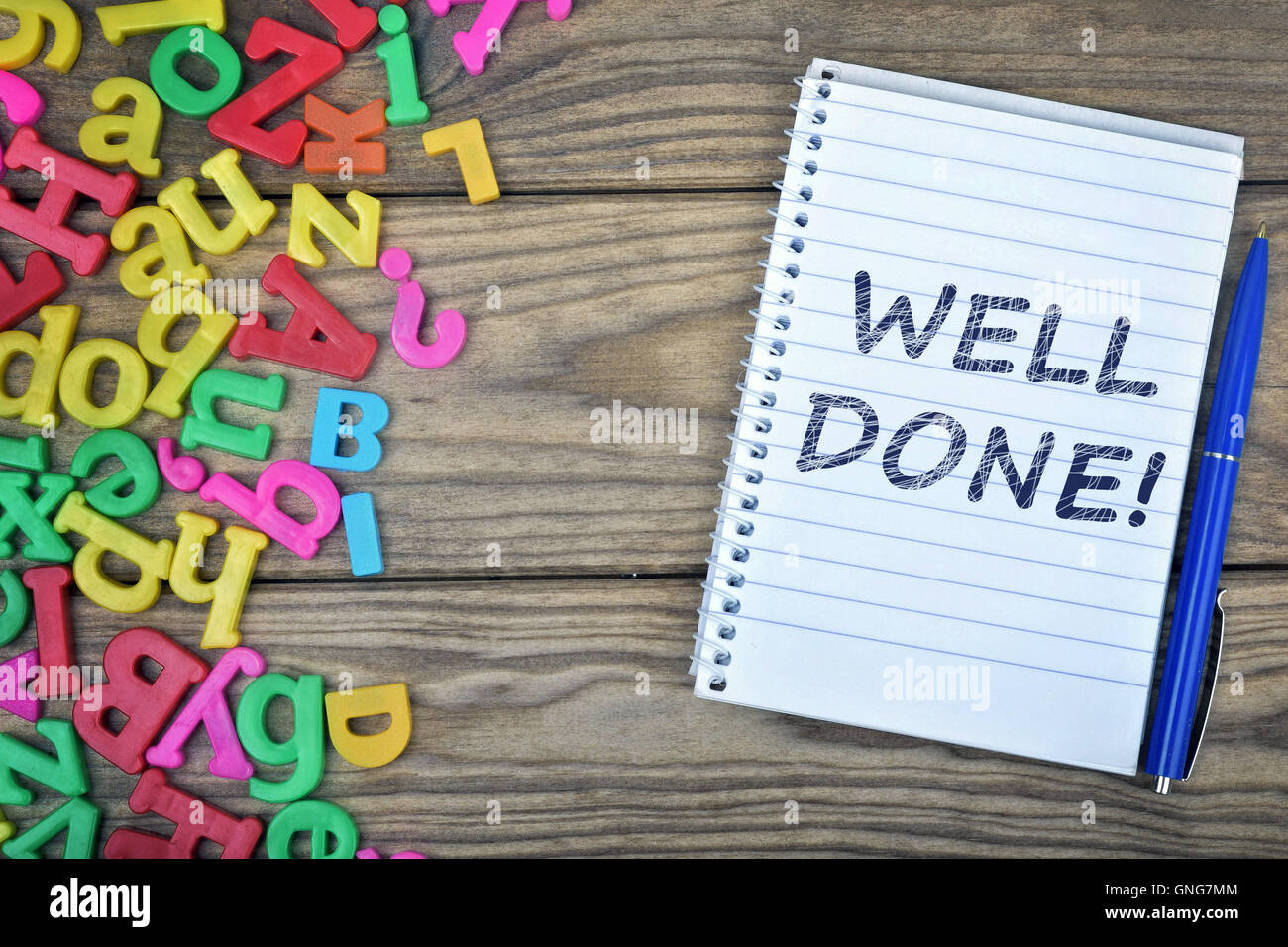 Well Done text on notepad and magnetic letters on wooden table Stock ...