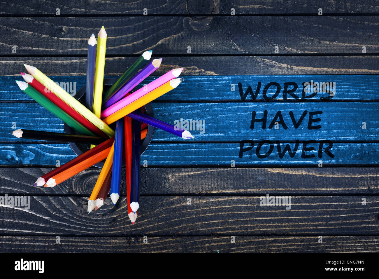 Words have power text painted and group of pencils on wooden table ...