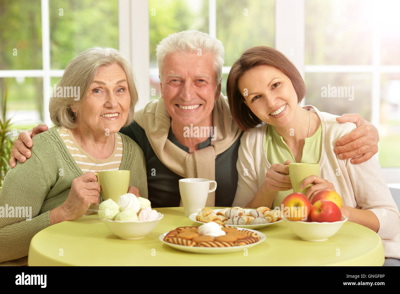 Daughter with senior parents drinking tea Stock Photo - Alamy