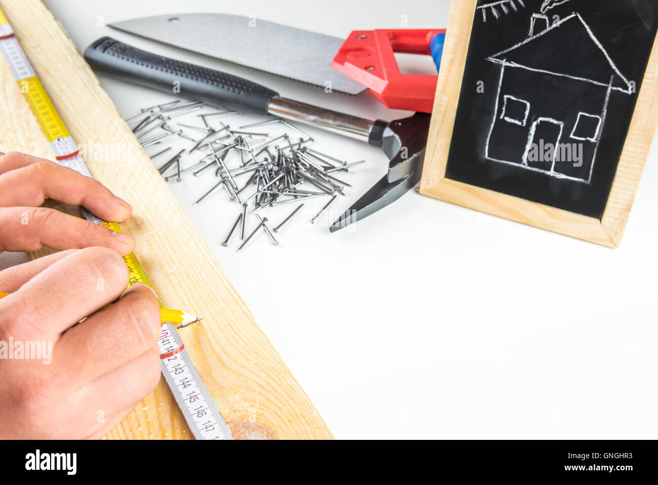Builders hands measuring a wooden plank Stock Photo - Alamy