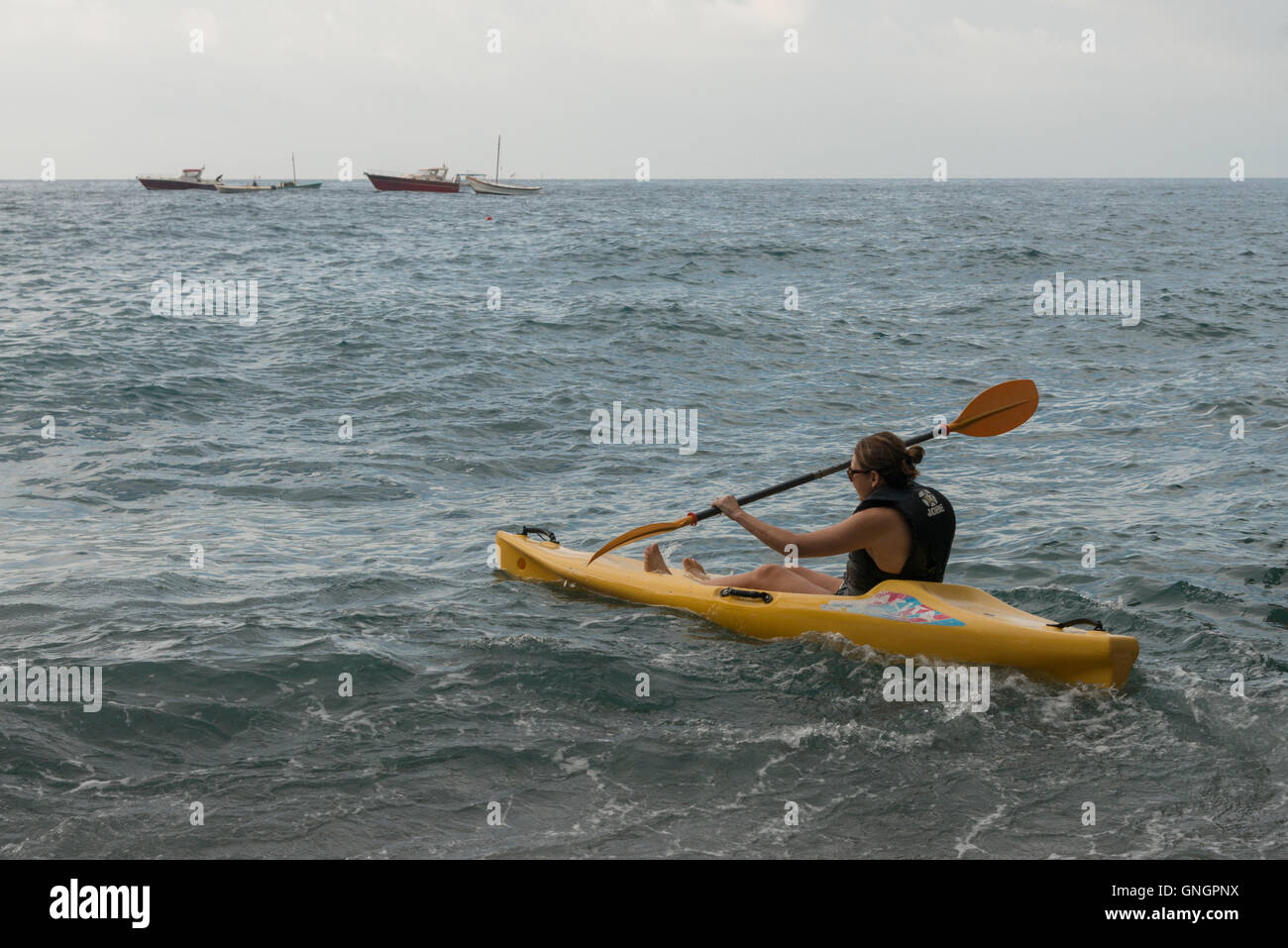 Woman rowing kayak in sea, Positano, Amalfi Coast, Salerno, Campania ...