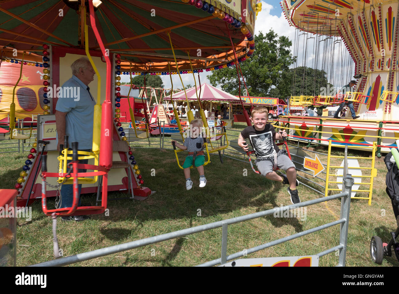 Children enjoying funfair chair ride roundabout at Stow cum Quy ...