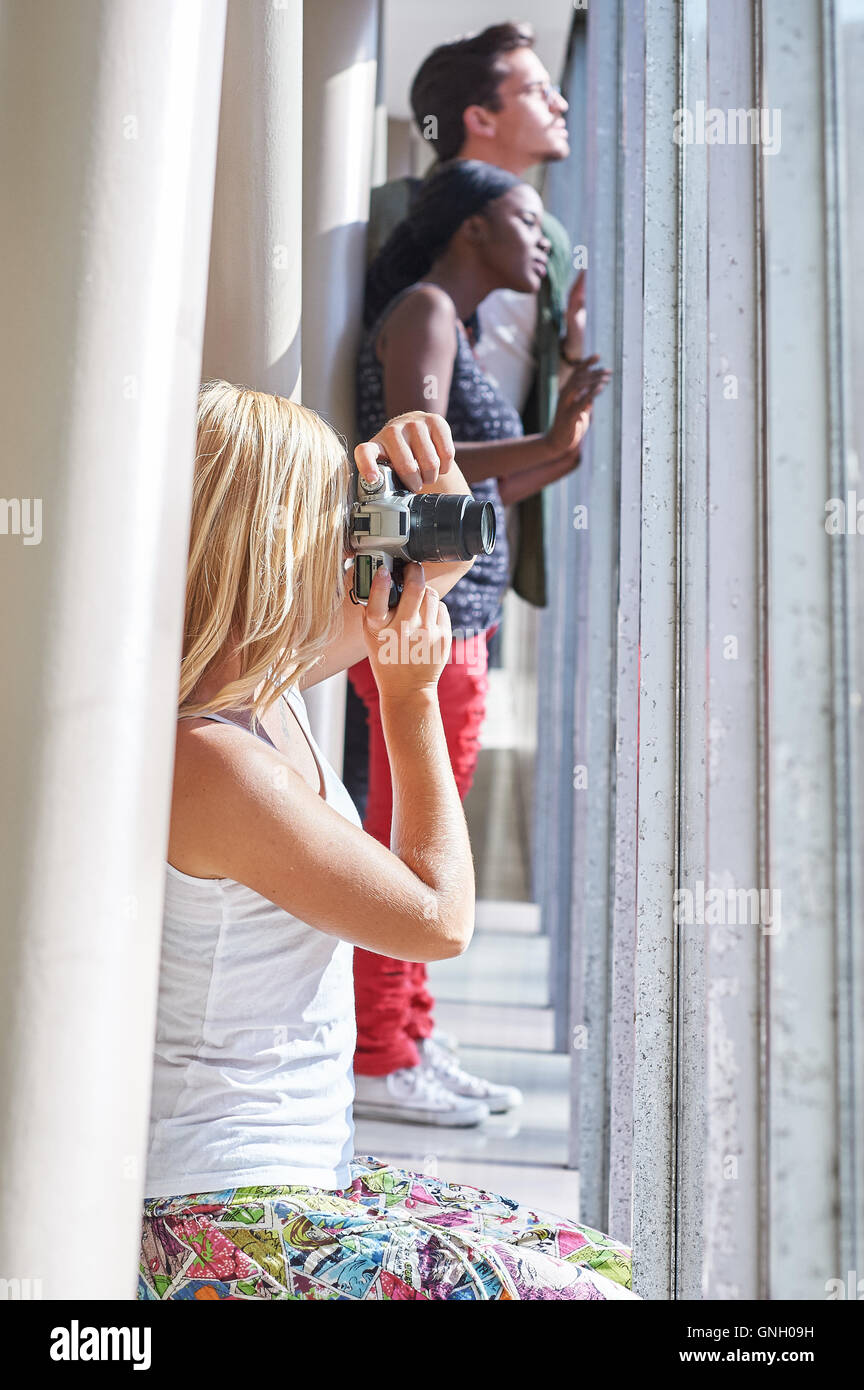 Girl taking photo out of window with people in background Stock Photo ...