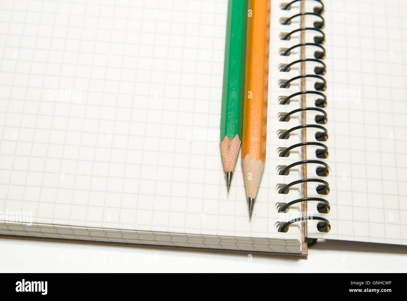 Opened notebook with a blank sheet and pencils on over white Stock ...