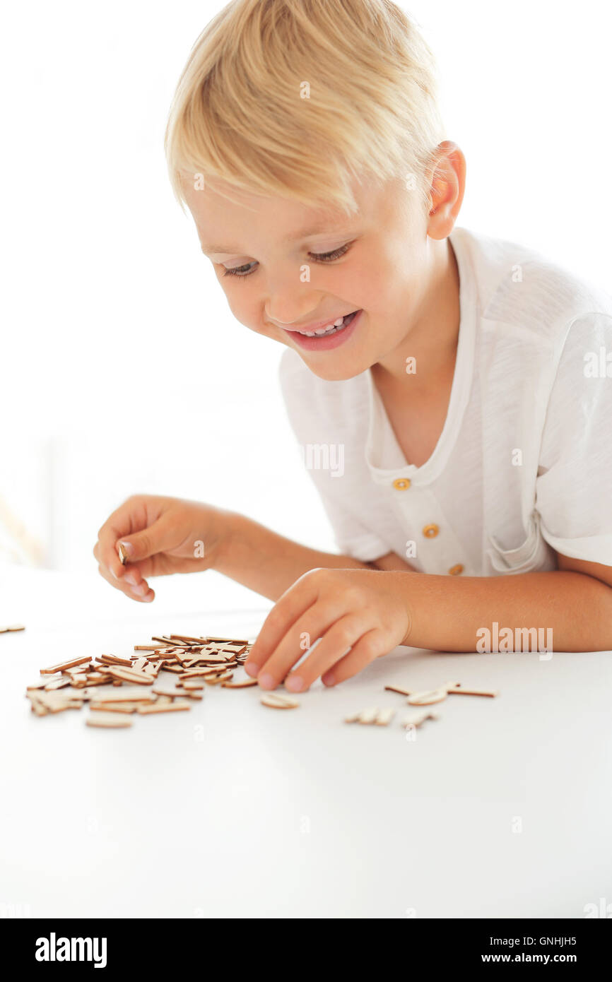 Educational fun, little boy puts puzzle Stock Photo - Alamy
