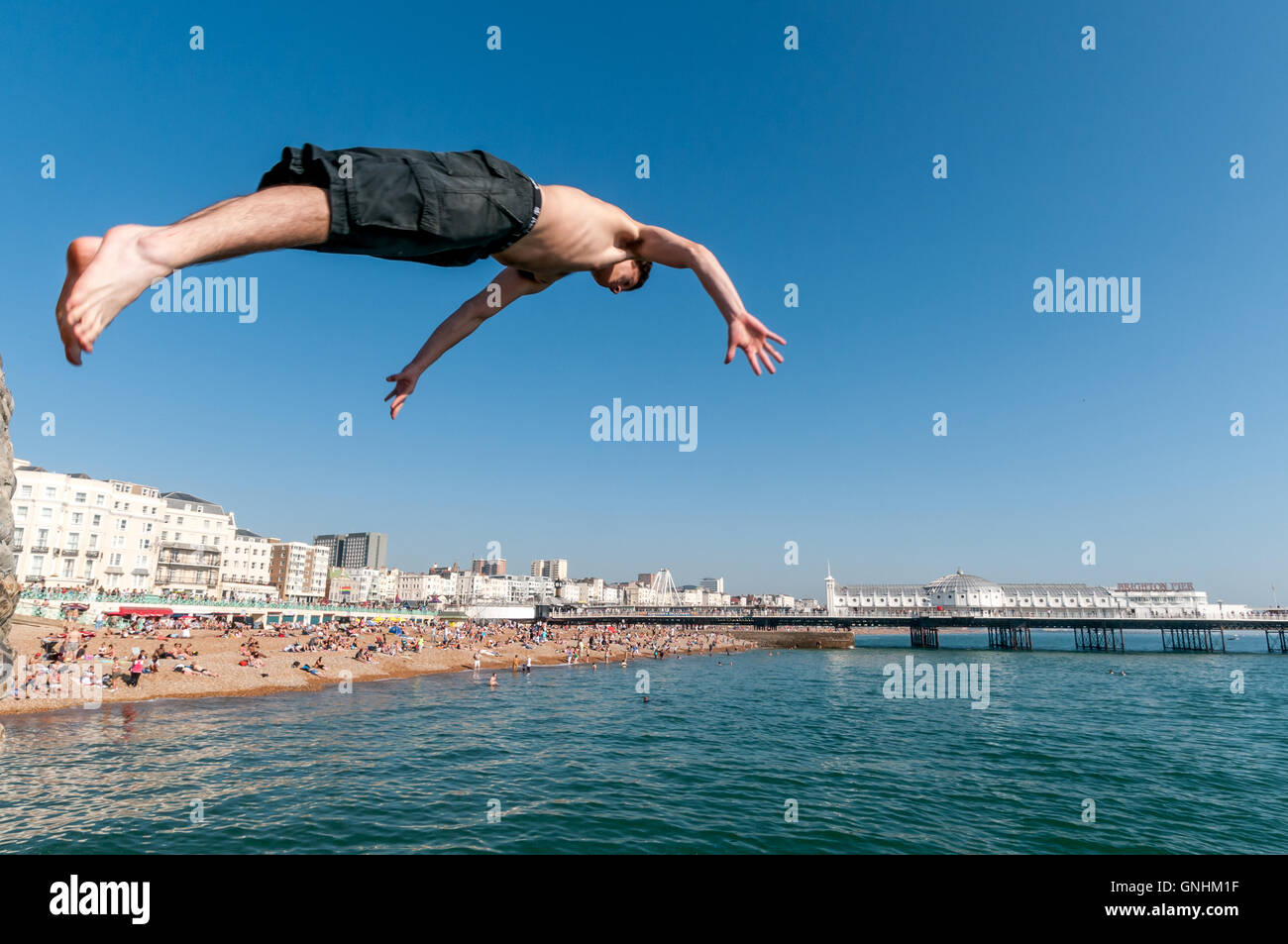 Young man jumping into the sea from the Banjo Groyne on the beach at ...