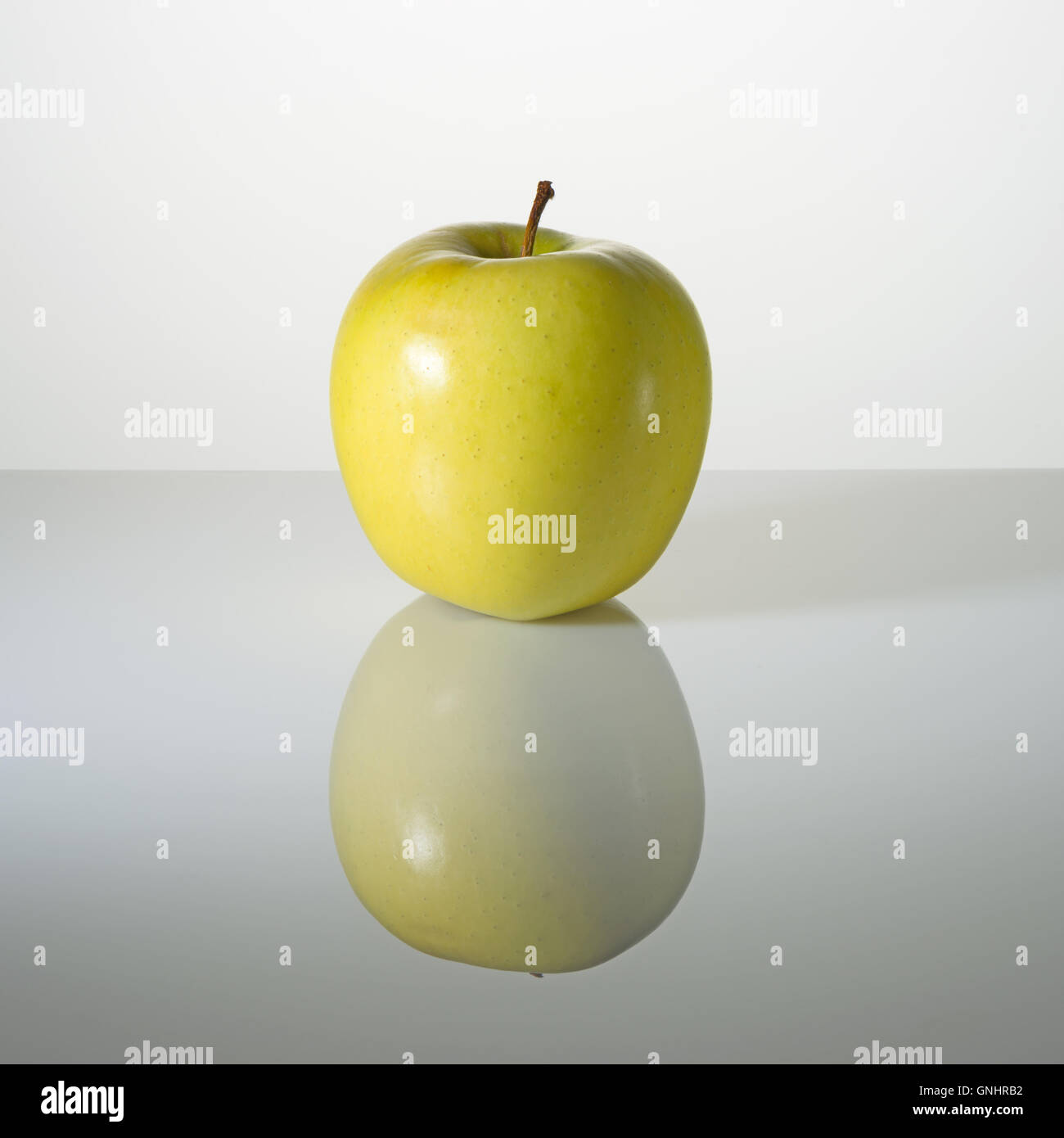 Green apple on a surface with reflection Stock Photo - Alamy