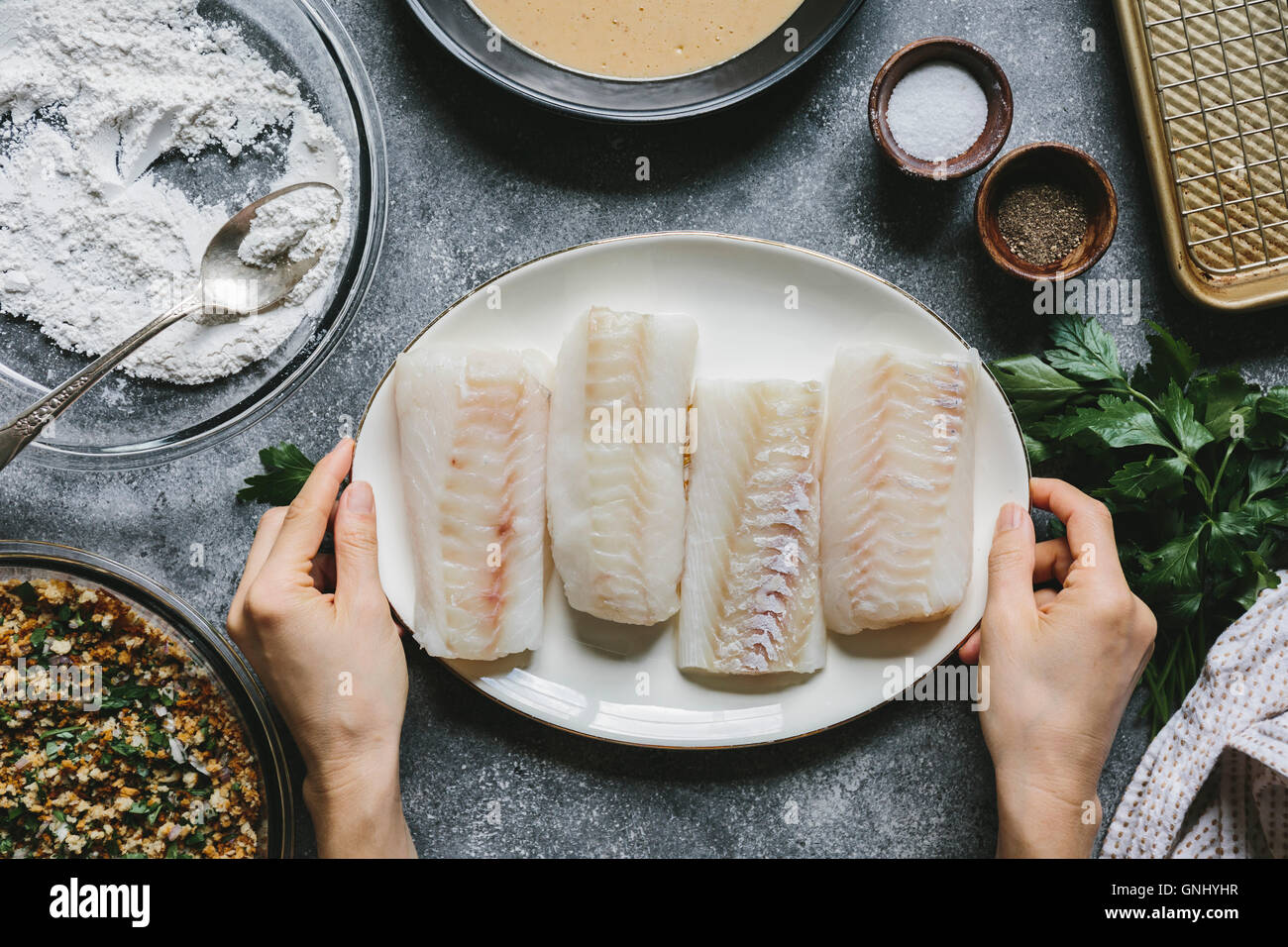 A woman is placing four cod fillets on the table Stock Photo - Alamy