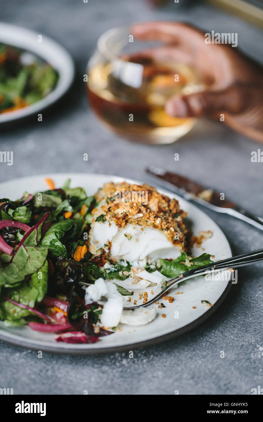A half eaten fried fish along with some salad is photographed from the ...