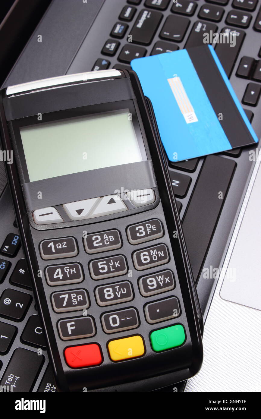 Payment terminal and credit card on laptop keyboard, credit card reader ...