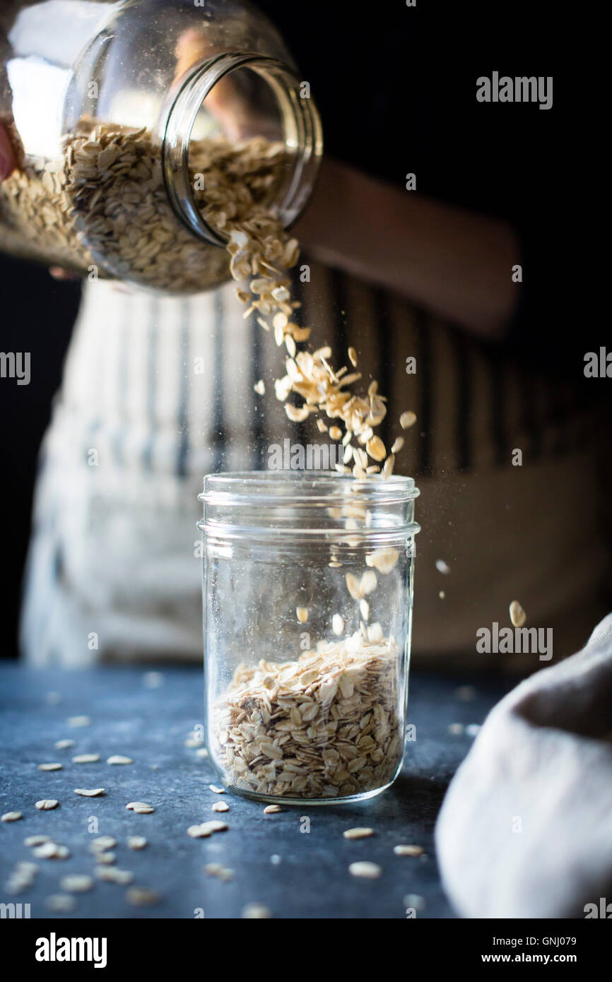 A woman pouring oats it to a jar Stock Photo - Alamy