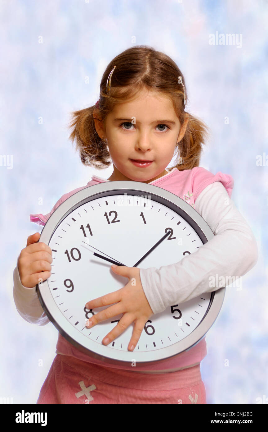 girl child holding a clock - activity schedule concept Stock Photo - Alamy