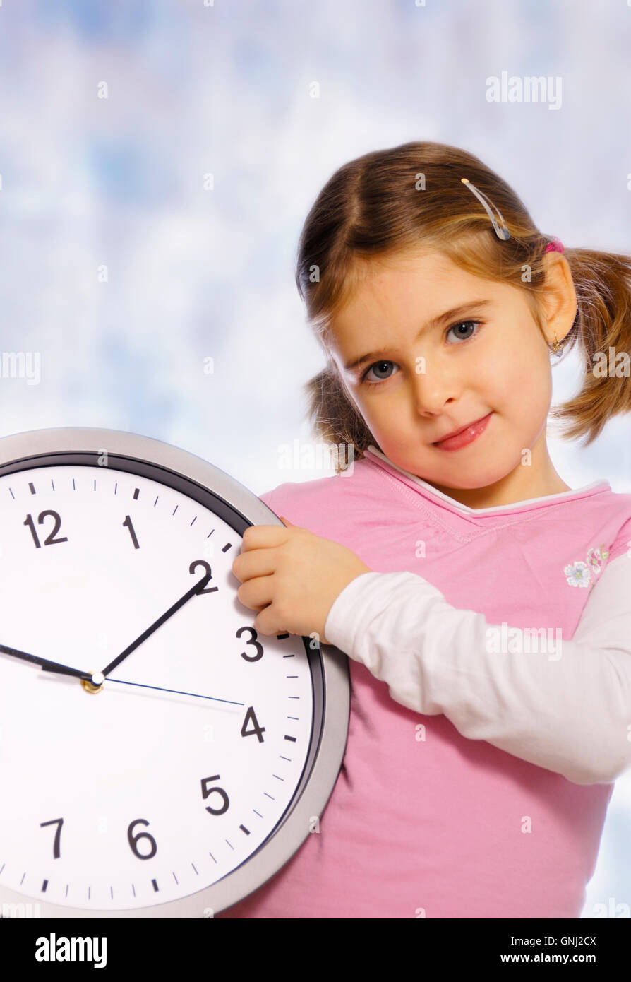 girl child holding a clock - activity schedule concept Stock Photo - Alamy
