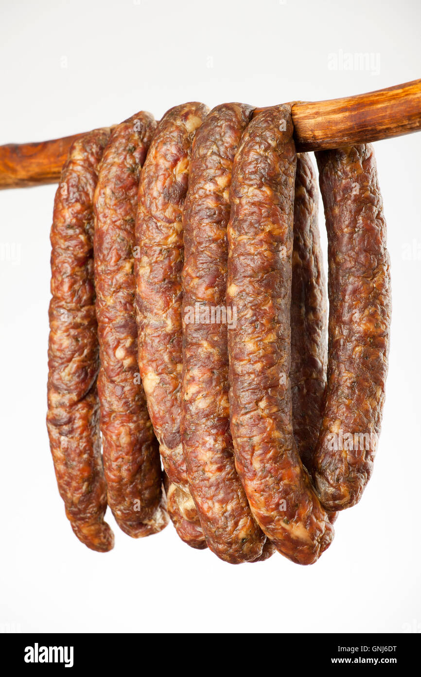 hanging smoked traditional sausage on a stick on white background Stock ...