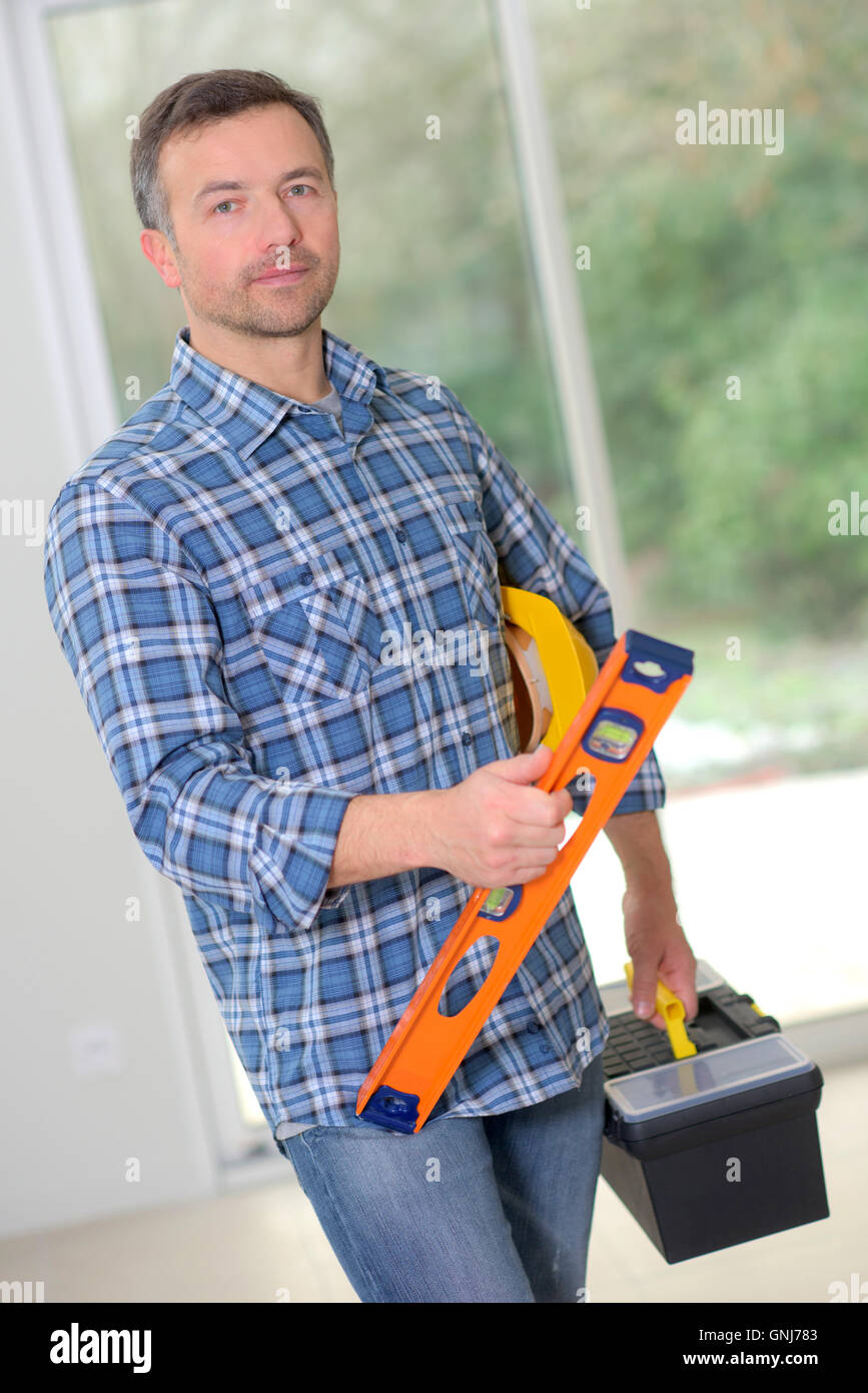 Builder using a spirit level Stock Photo - Alamy