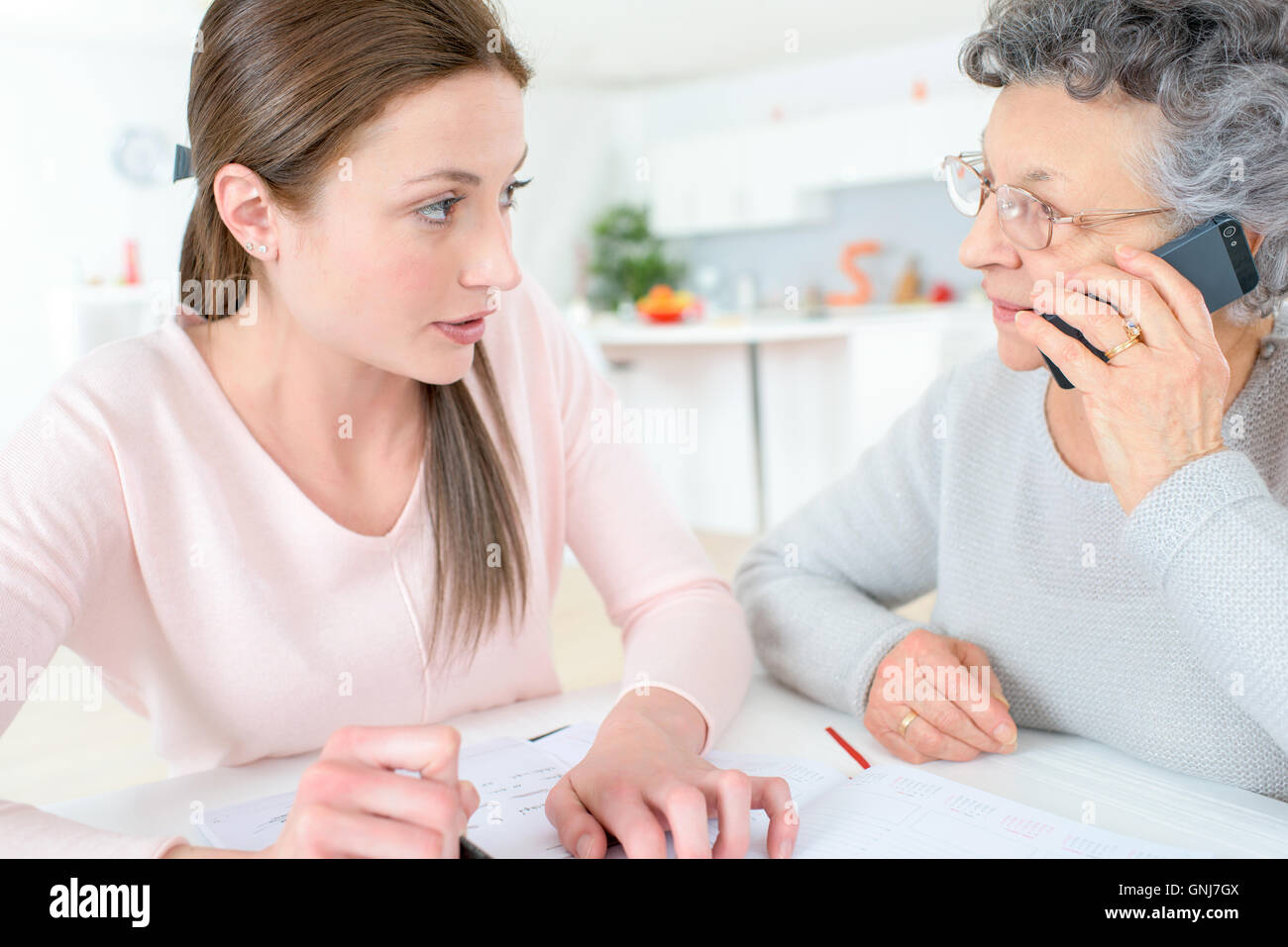 Helping confused lady make a call Stock Photo - Alamy