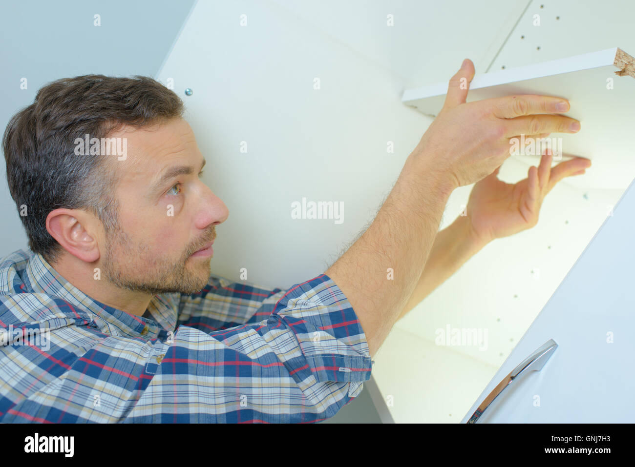 Man fitting some new kitchen units Stock Photo - Alamy