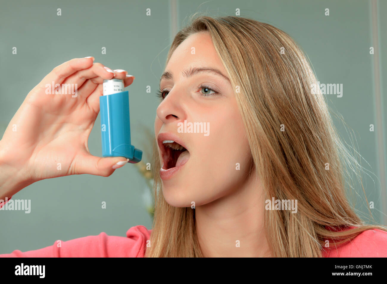 Woman taking her inhaler Stock Photo - Alamy