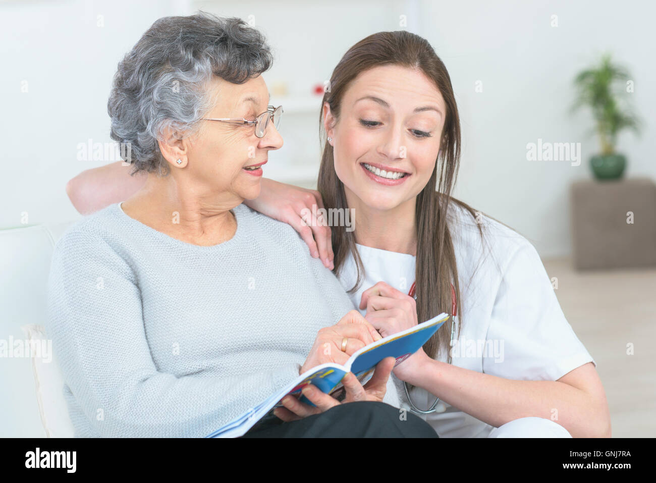 Helping old lady to read Stock Photo - Alamy