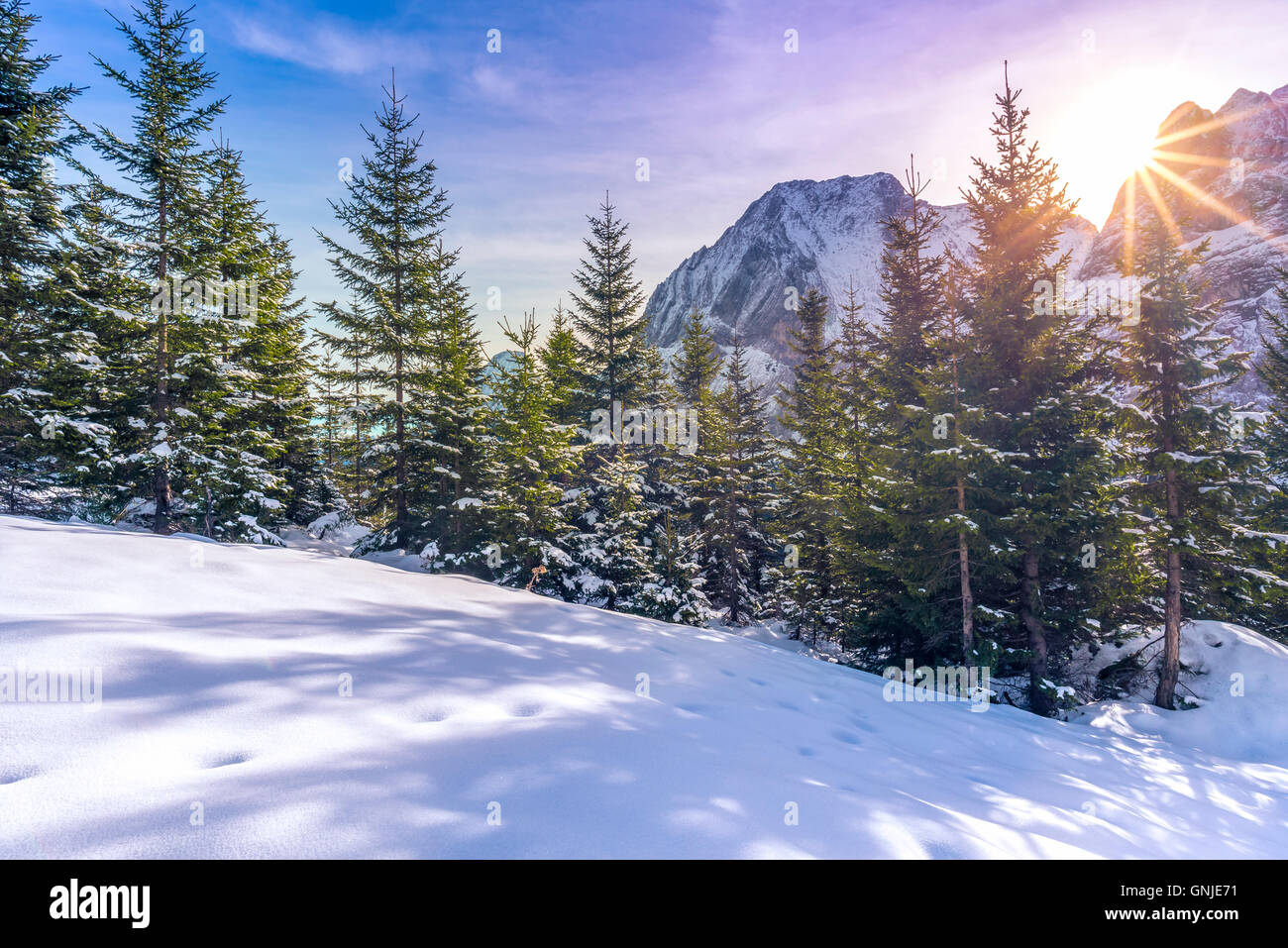 Sun rays over snowy alpine scene Stock Photo - Alamy