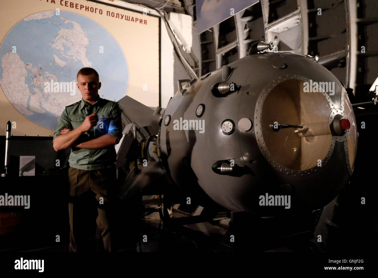 A uniformed Russian guide stands next to the first Soviet atomic bomb ...