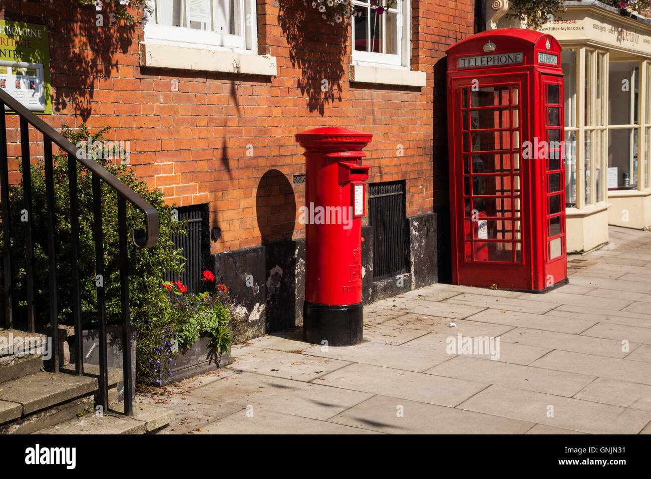 Red round post box and traditional red telephone box outside Ashbourne ...