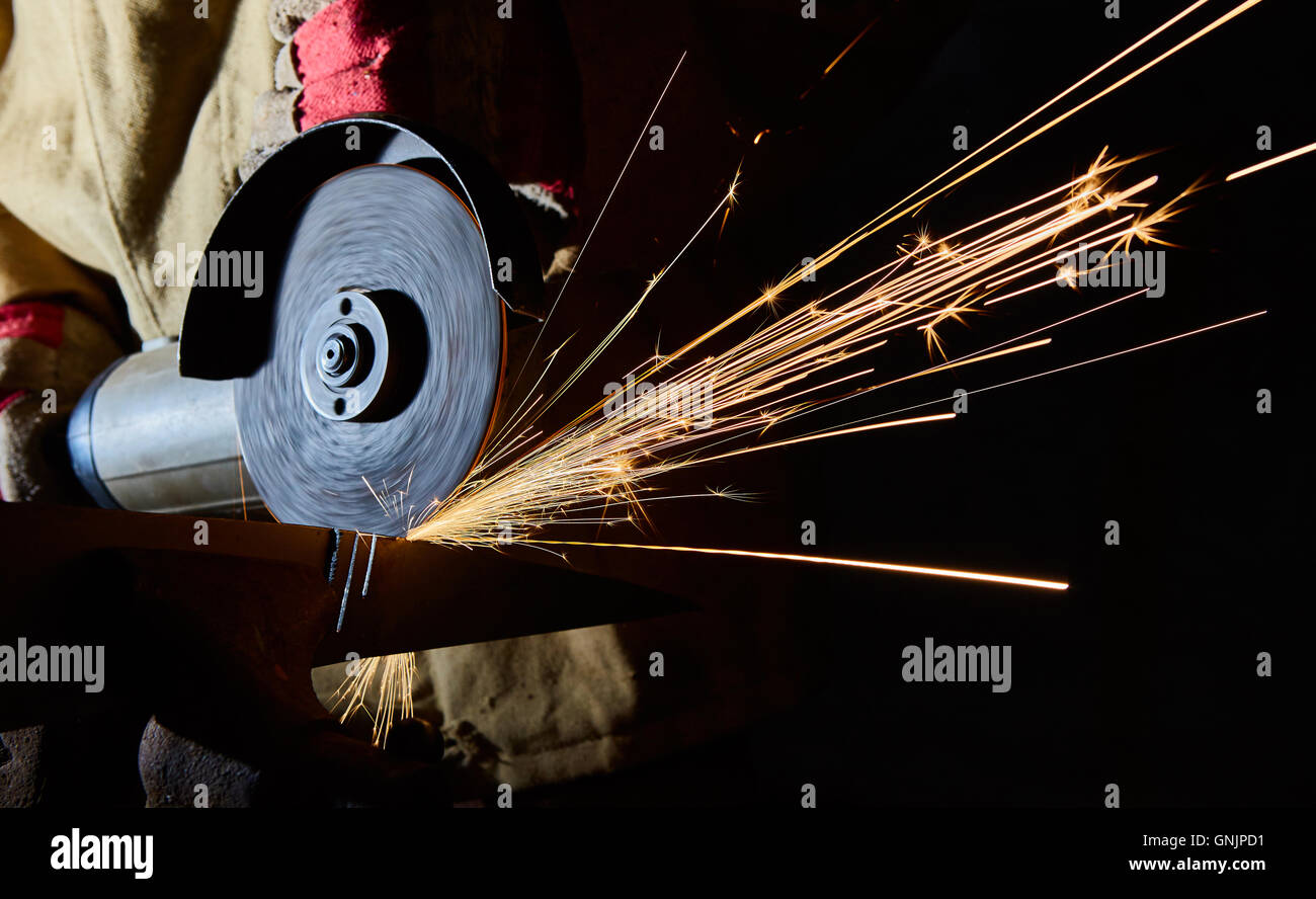 Worker cutting metal with grinder. Sparks while grinding iron Stock ...