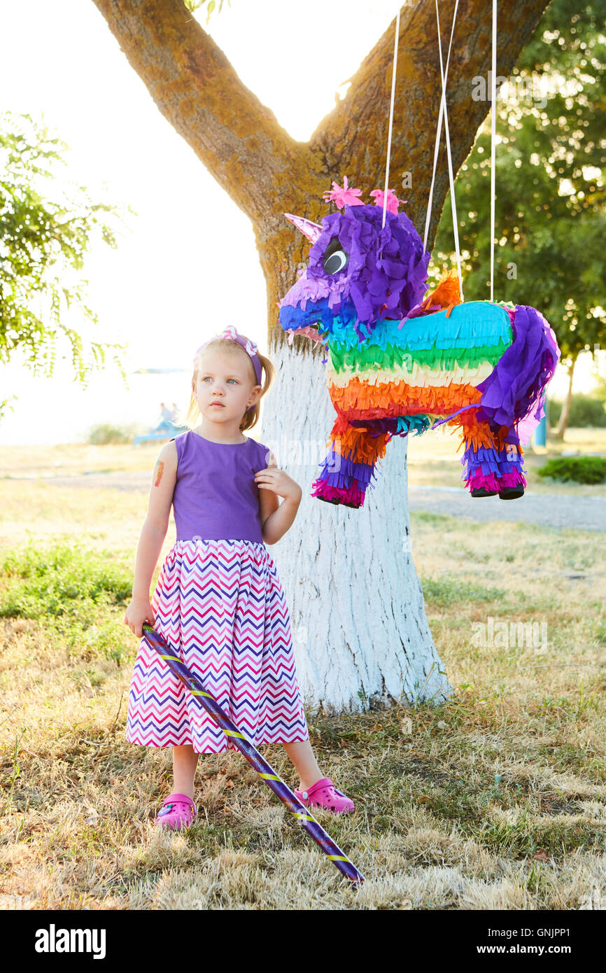 Young girl at an outdoor party hitting a pinata Stock Photo - Alamy