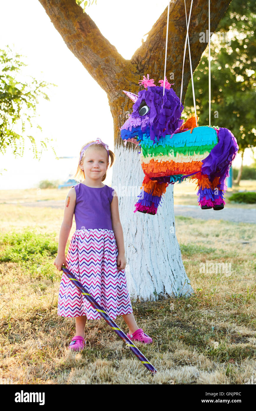 Young girl at an outdoor party hitting a pinata Stock Photo - Alamy
