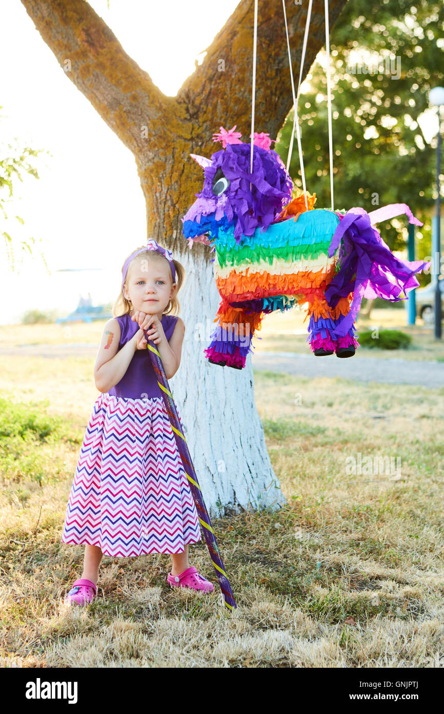 Young girl at an outdoor party hitting a pinata Stock Photo - Alamy