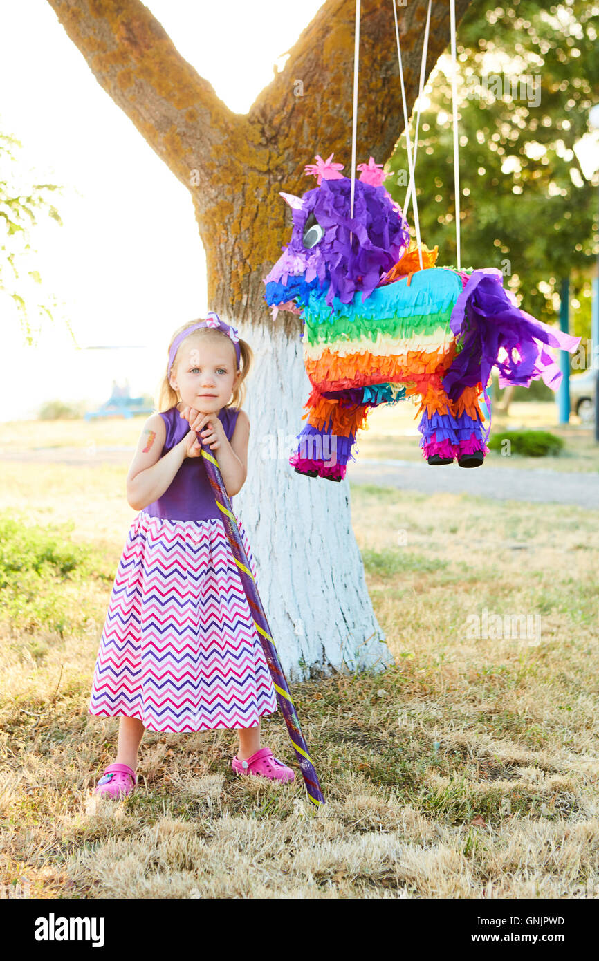 Young girl at an outdoor party hitting a pinata Stock Photo - Alamy