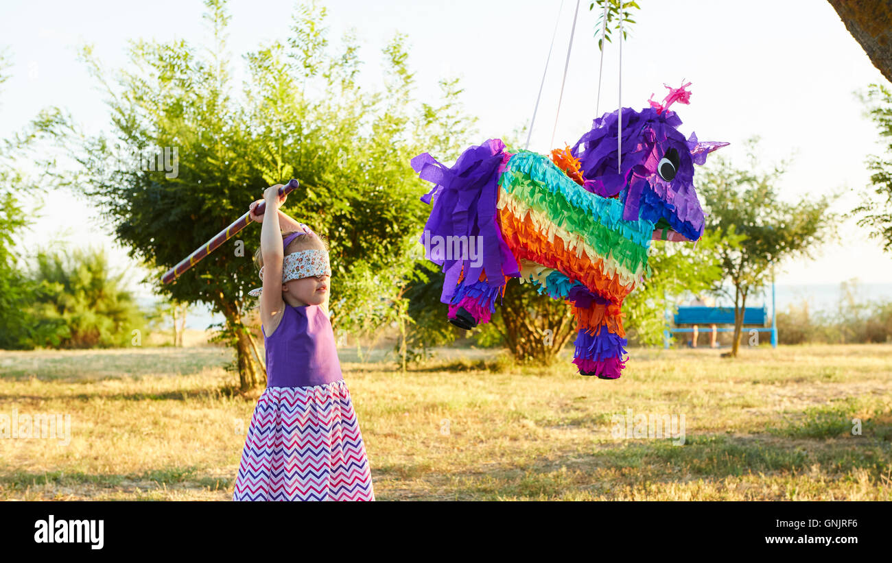 Young girl at an outdoor party hitting a pinata Stock Photo - Alamy