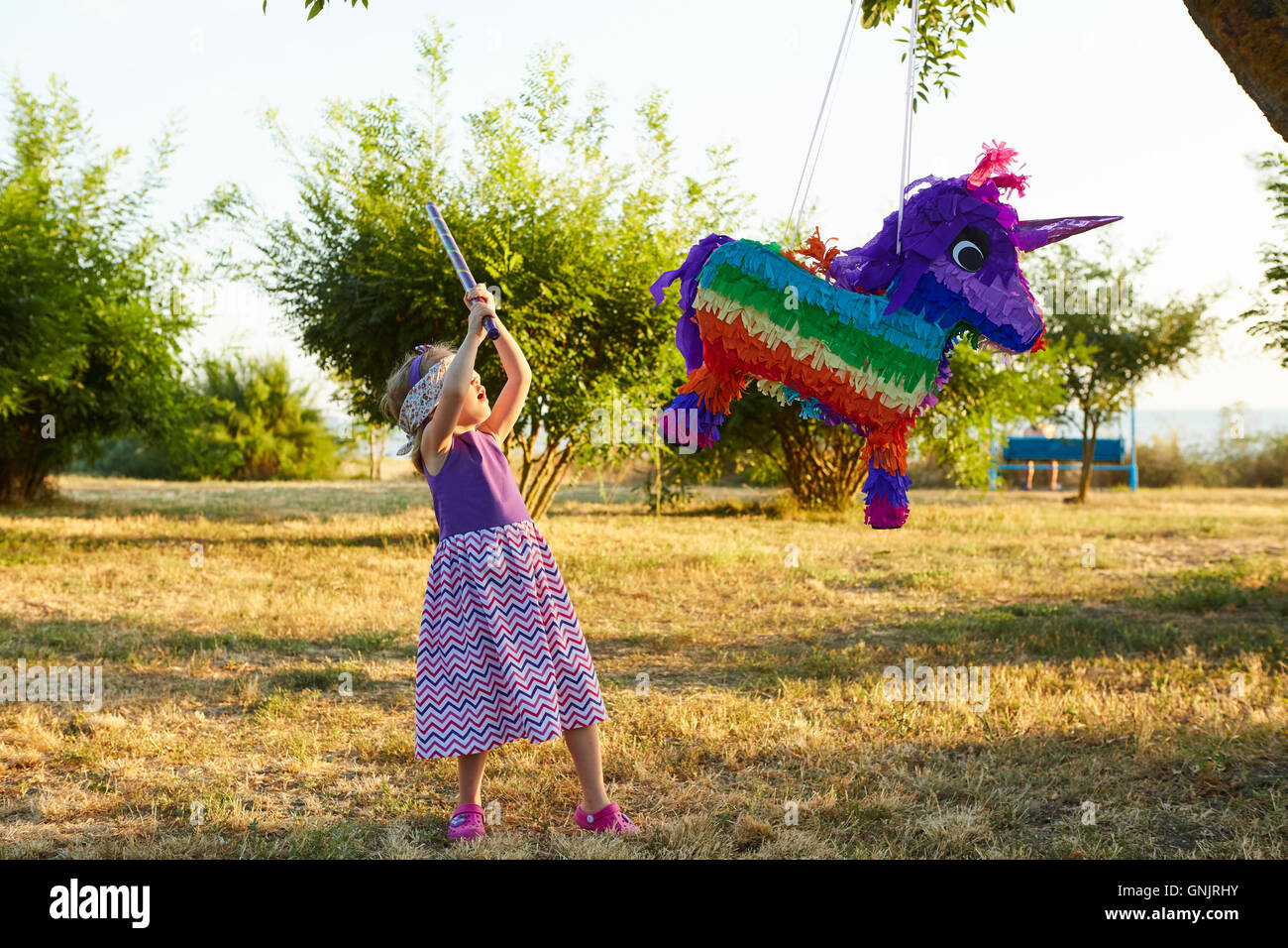Young girl at an outdoor party hitting a pinata Stock Photo - Alamy