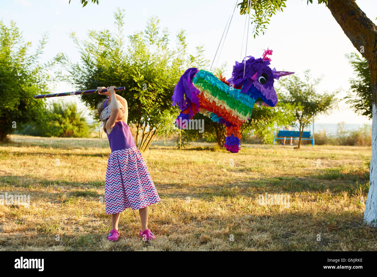 Young girl at an outdoor party hitting a pinata Stock Photo - Alamy