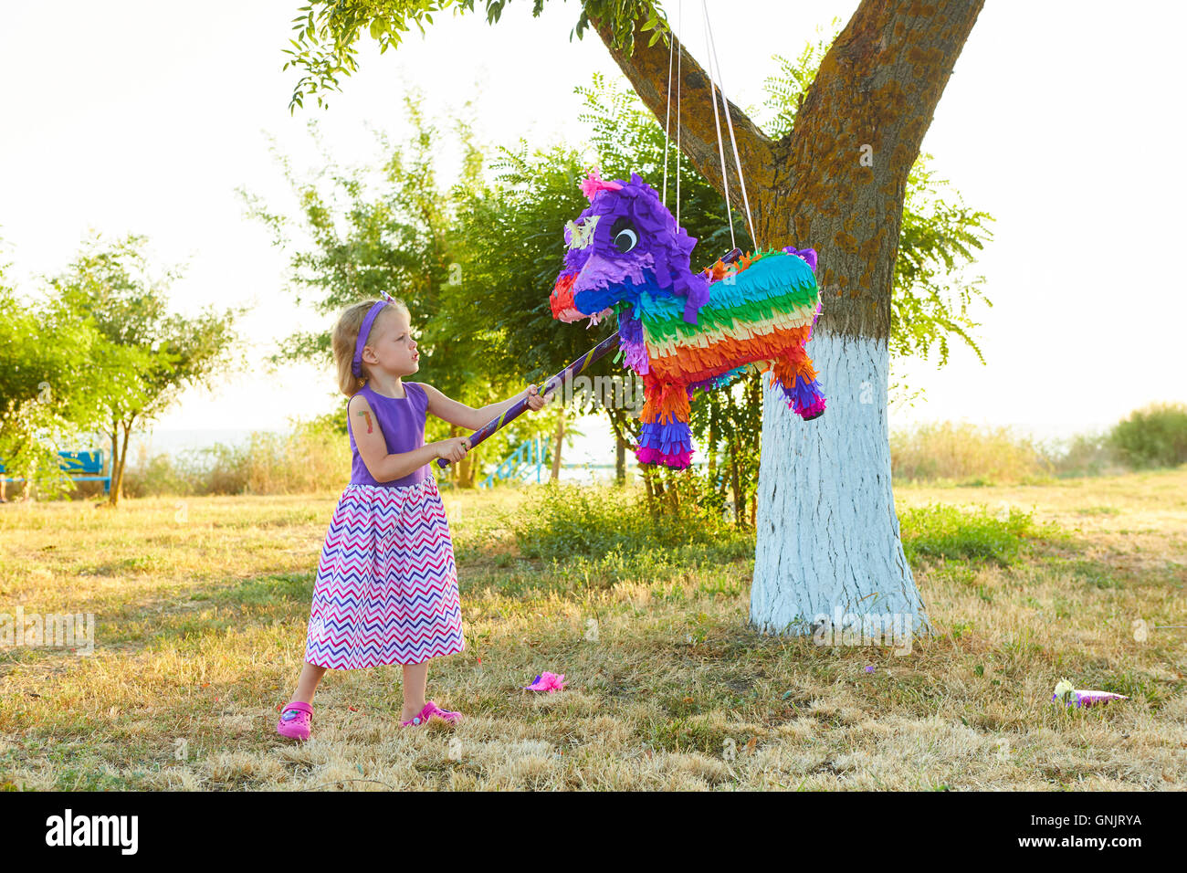 Young girl at an outdoor party hitting a pinata Stock Photo - Alamy