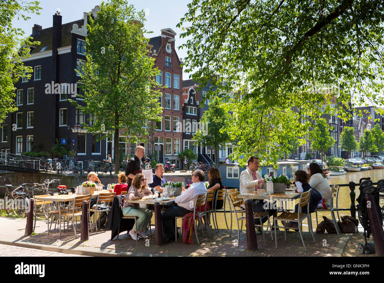 Diners dining al fresco at pavement canalside cafe by Brouwersgracht ...