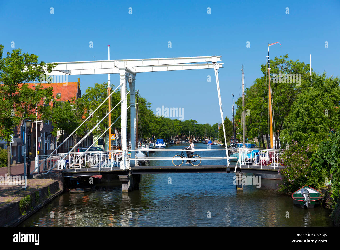 Woman cyclist cycling on bascule vertical-lift bridge, lift up ...