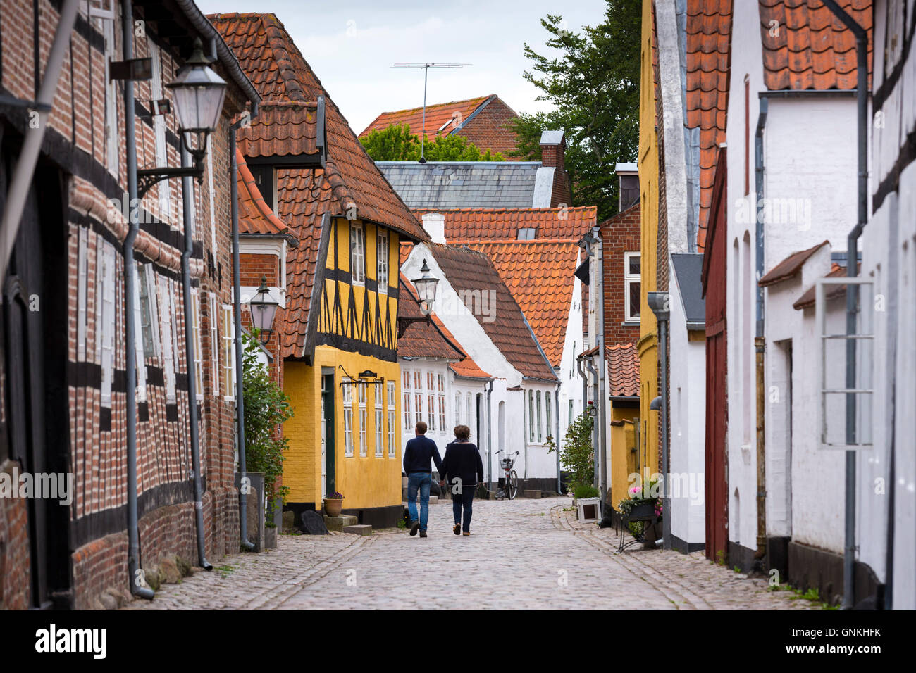 Couple strolling along traditional medieval street in Ribe centre ...
