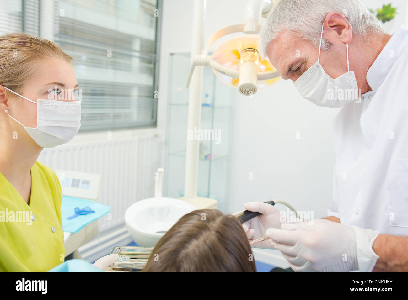 Busy dentist with a patient Stock Photo - Alamy