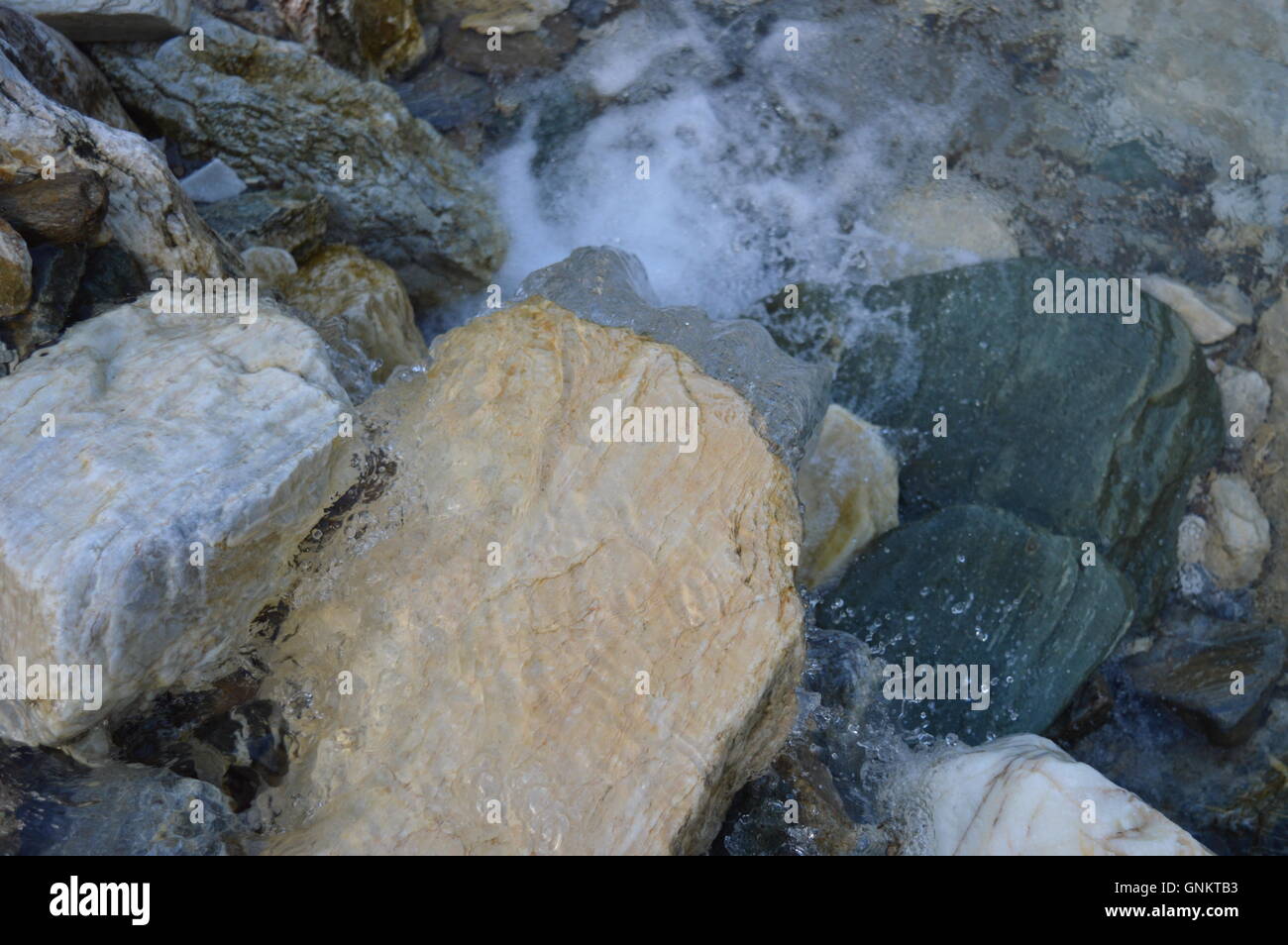 Water flowing over a rock forming a small waterfall Stock Photo - Alamy