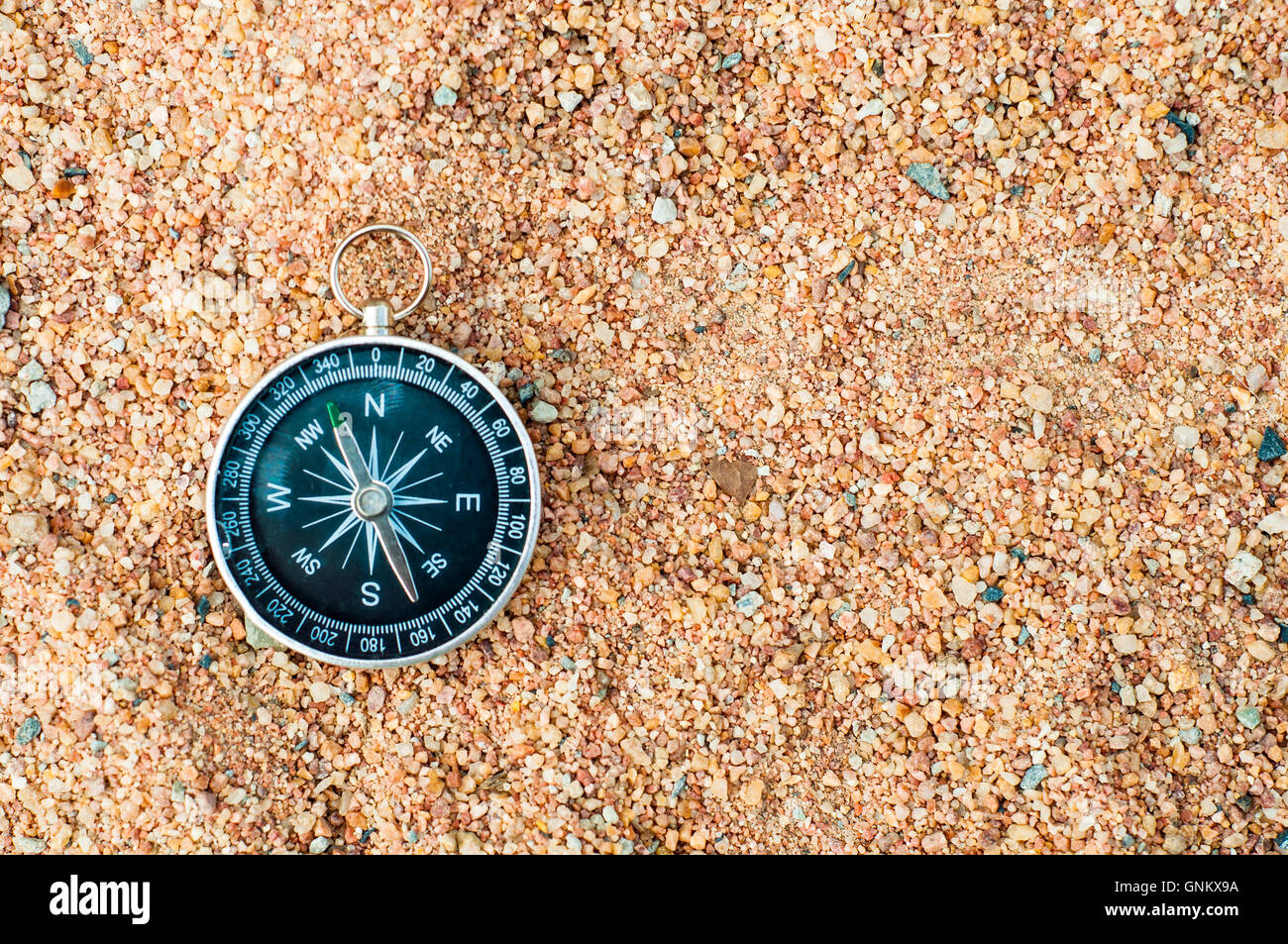 Top view to compass on sandy ground Stock Photo - Alamy