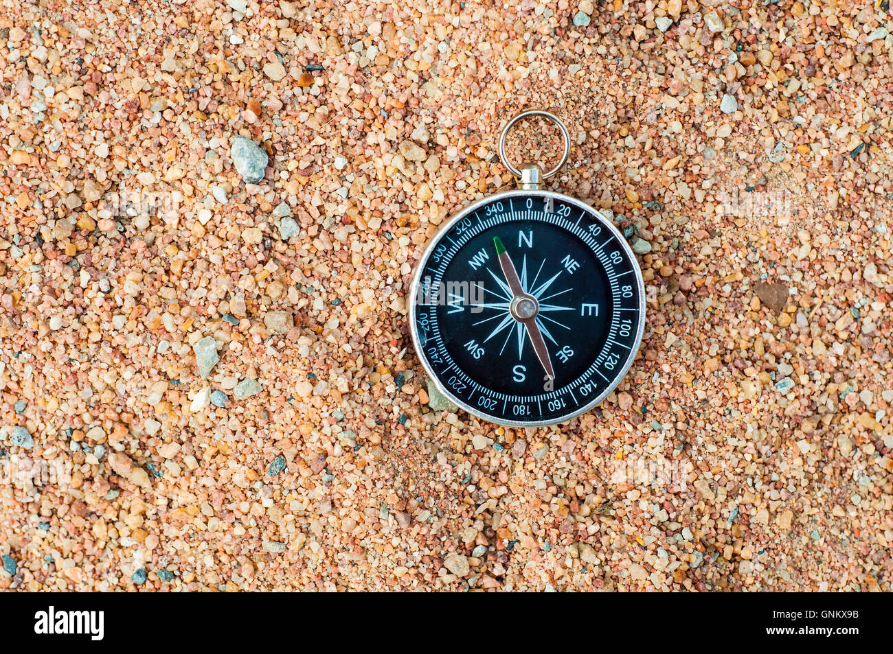 Top view to compass on sandy ground Stock Photo - Alamy