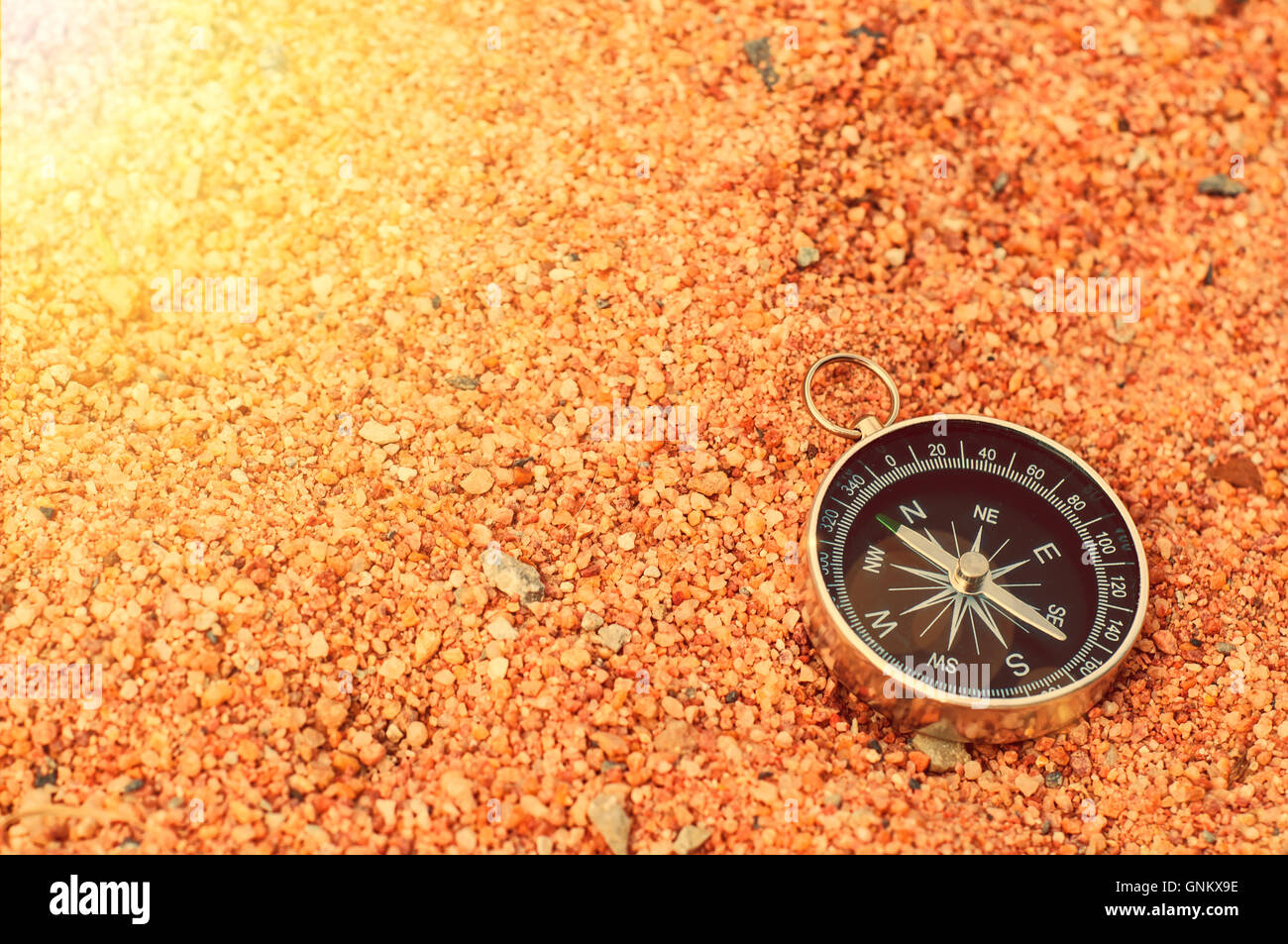 Compass on the sand under sun light Stock Photo - Alamy
