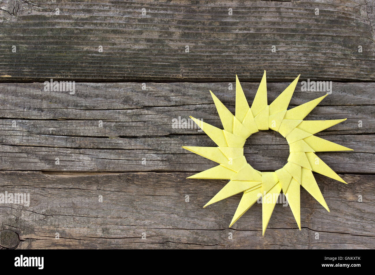 Origami yellow paper sun on wooden background Stock Photo - Alamy