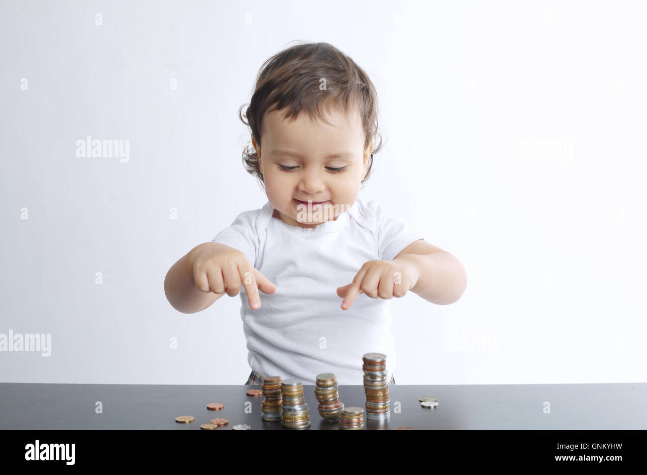 little boy playing with coins Stock Photo - Alamy