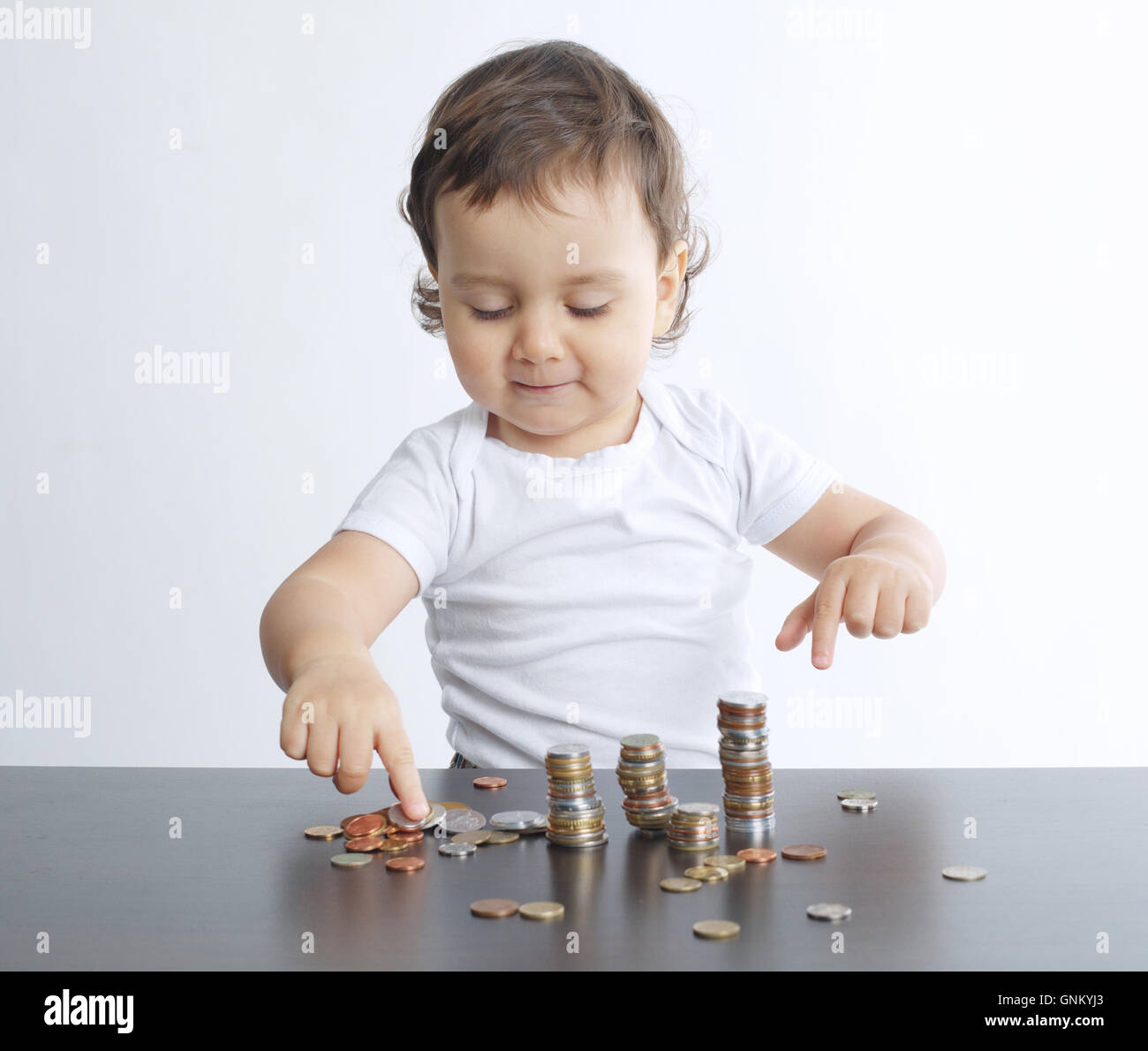 little boy playing with coins Stock Photo - Alamy